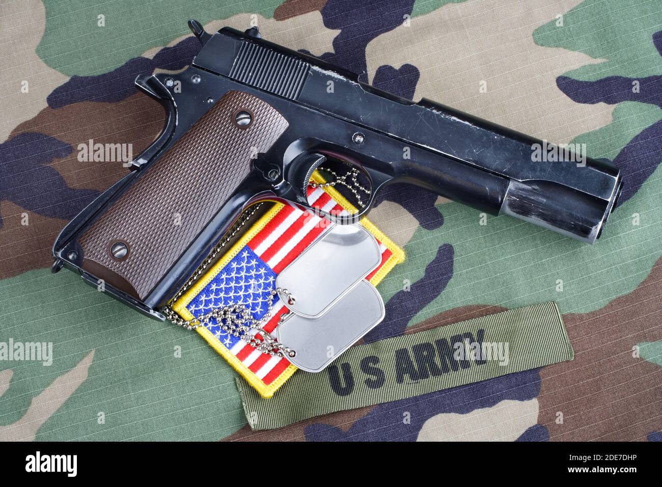 US ARMY branch tape, M1911 handgun with dog tags on woodland camouflage ...