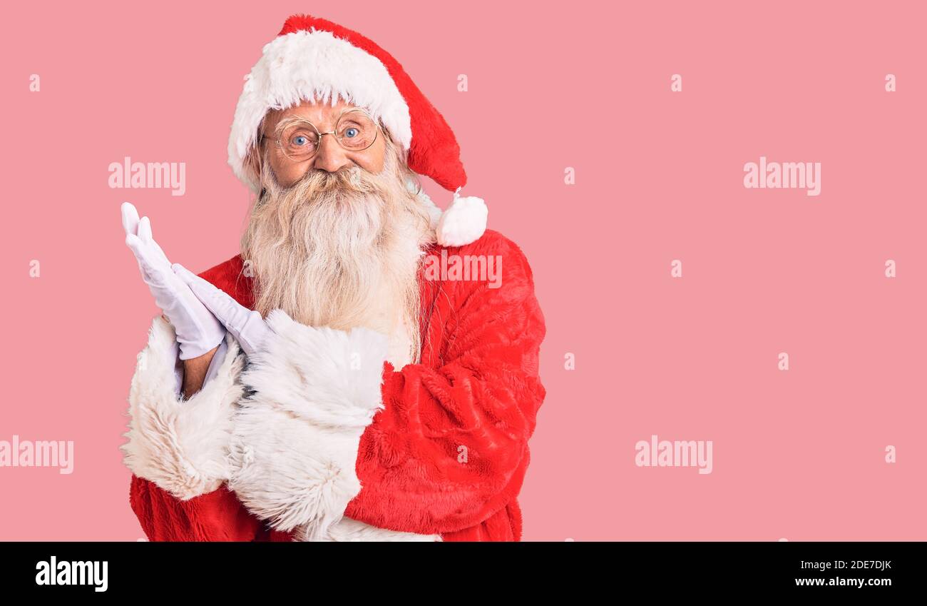Old senior man with grey hair and long beard wearing traditional santa ...