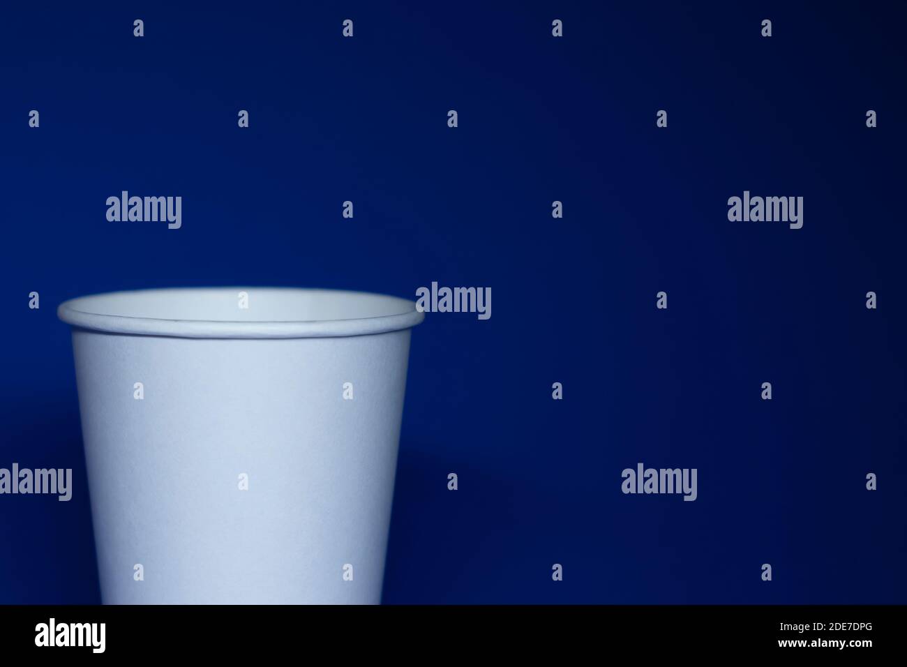 An empty white paper cup on a blue background. horizontal photo Stock ...