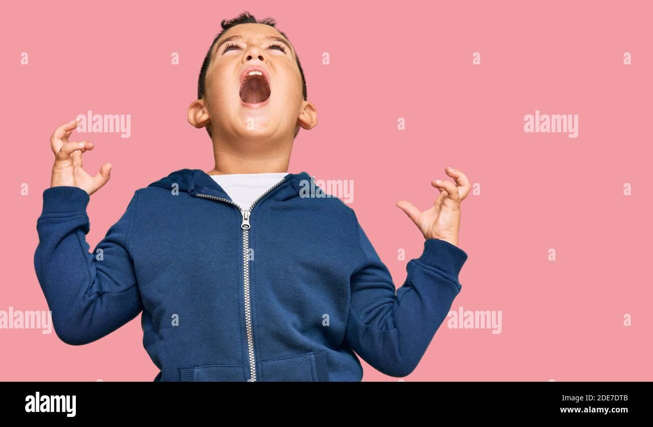 Little boy hispanic kid wearing casual sporty jacket crazy and mad ...