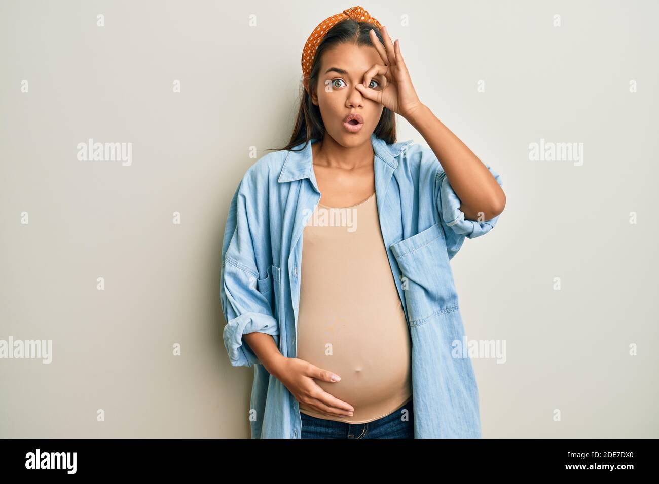 Beautiful hispanic woman expecting a baby, touching pregnant belly ...