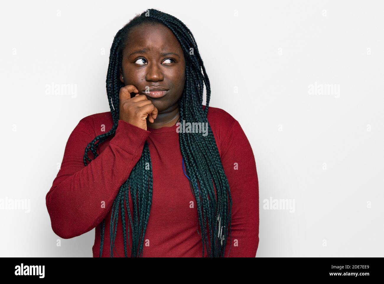 Young black woman with braids wearing casual clothes serious face ...