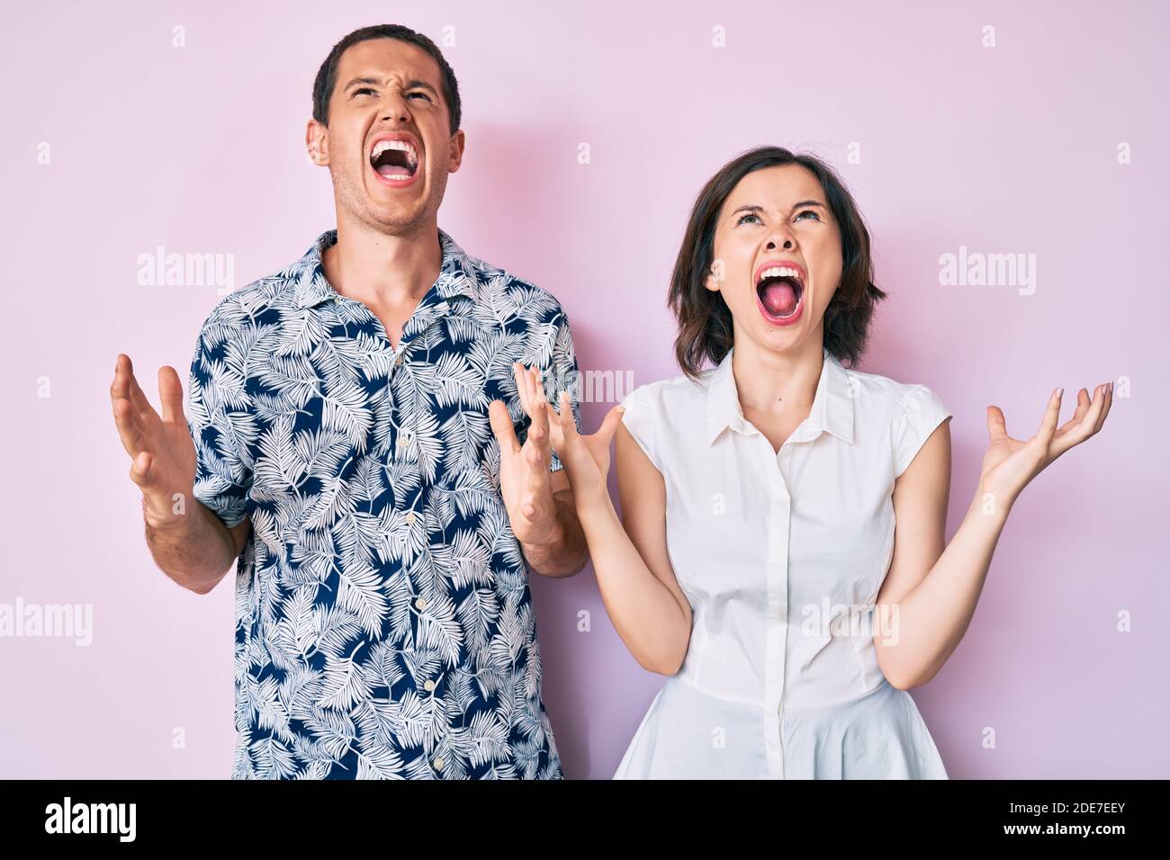 Beautiful couple wearing casual clothes crazy and mad shouting and ...