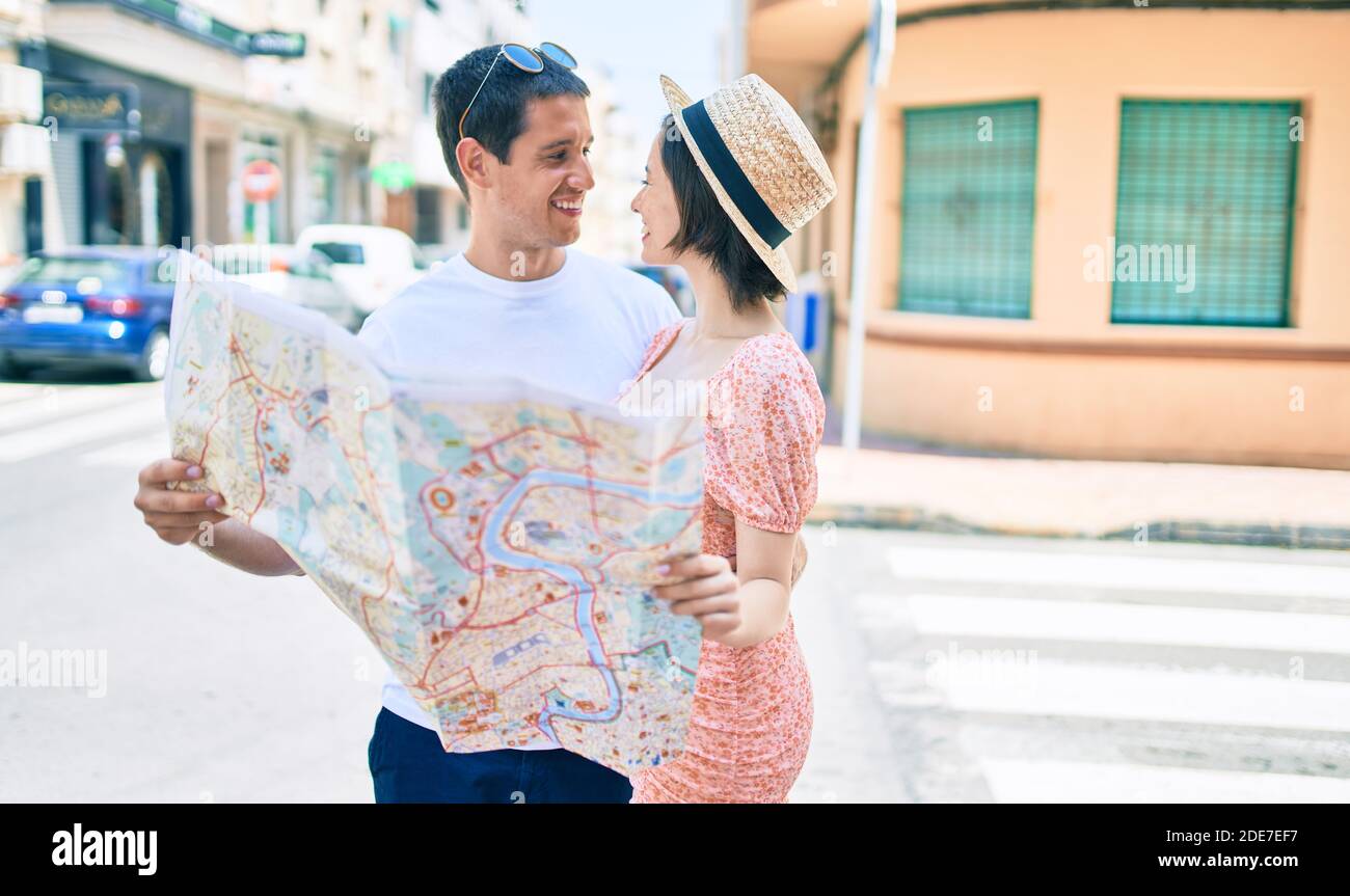 Beautiful couple on vacation smiling happy holding city map at street ...