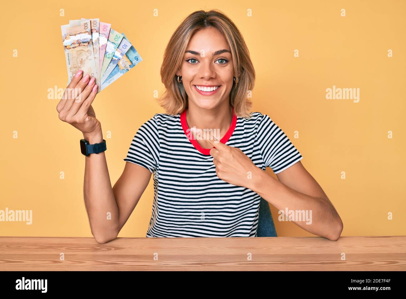 Beautiful caucasian woman holding canadian dollars smiling happy ...