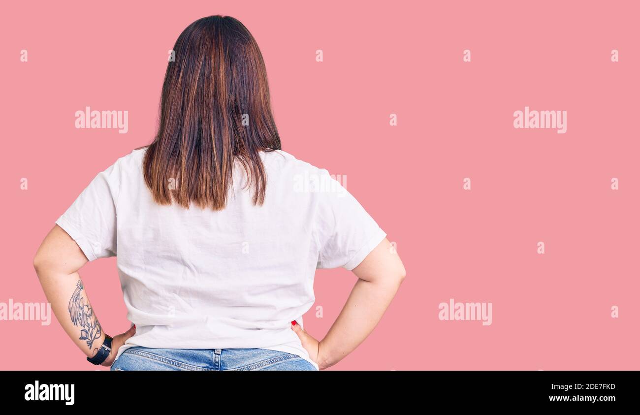 Young plus size woman wearing casual clothes standing backwards looking ...