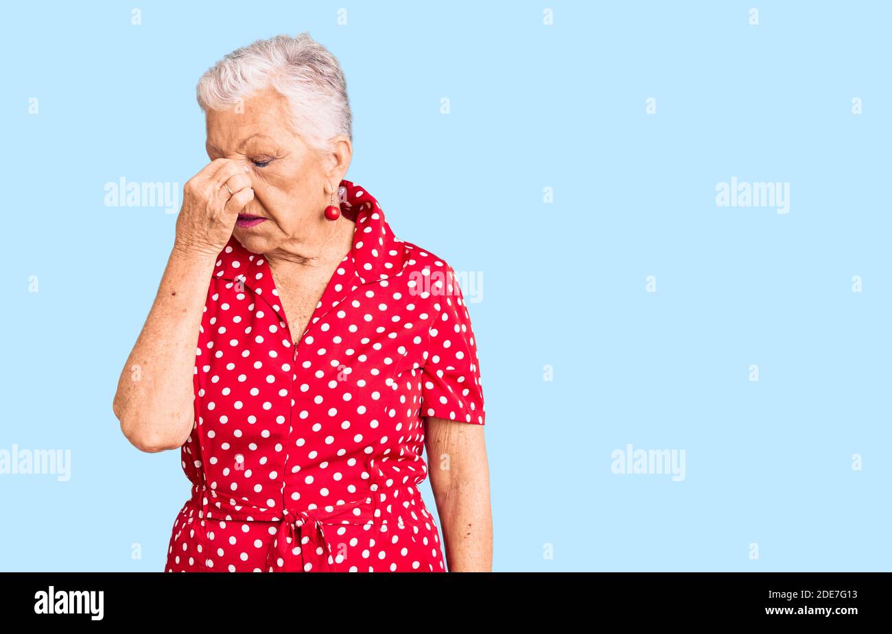Senior beautiful woman with blue eyes and grey hair wearing a red ...
