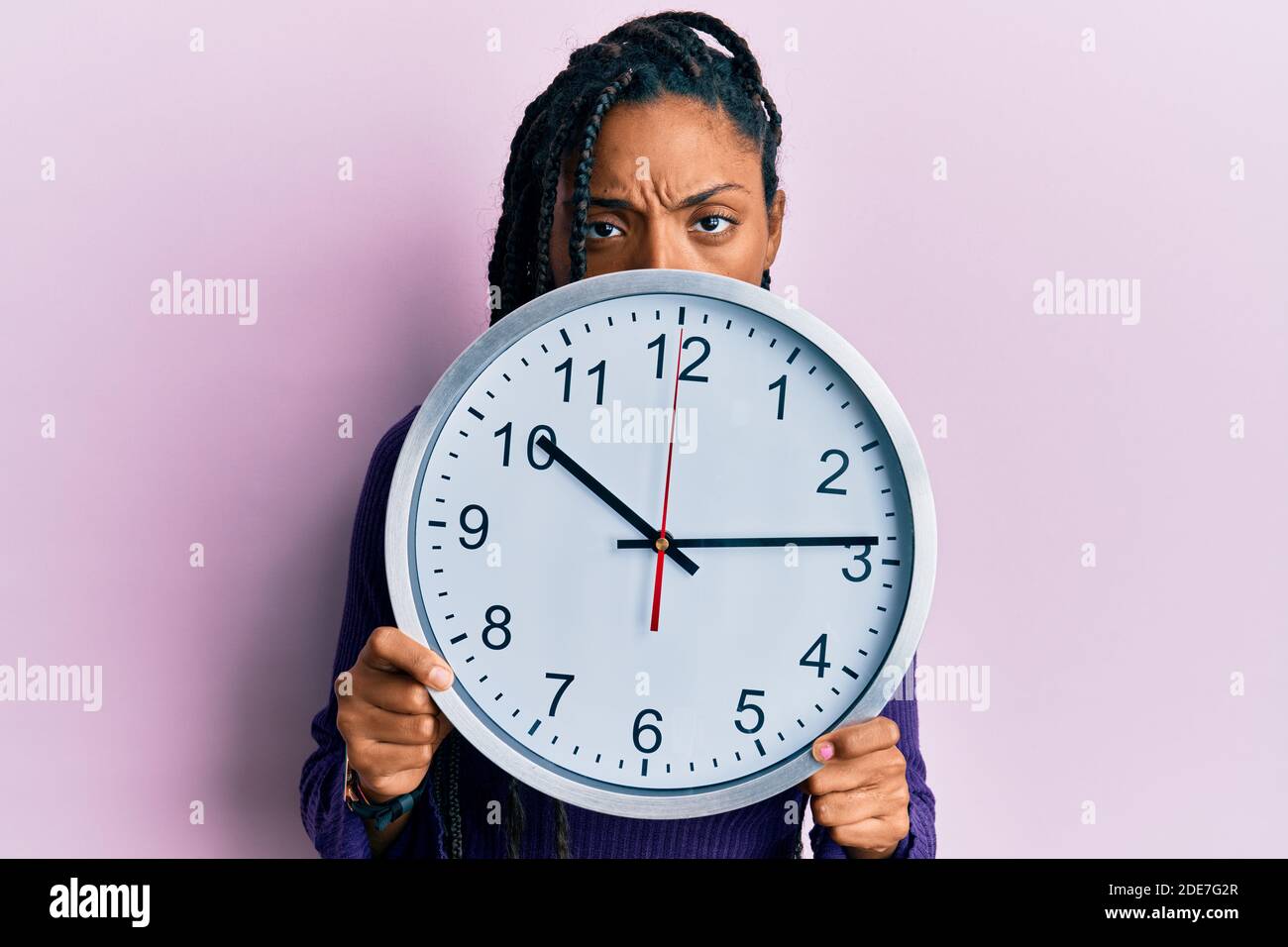 African american woman with braids holding big clock covering face ...