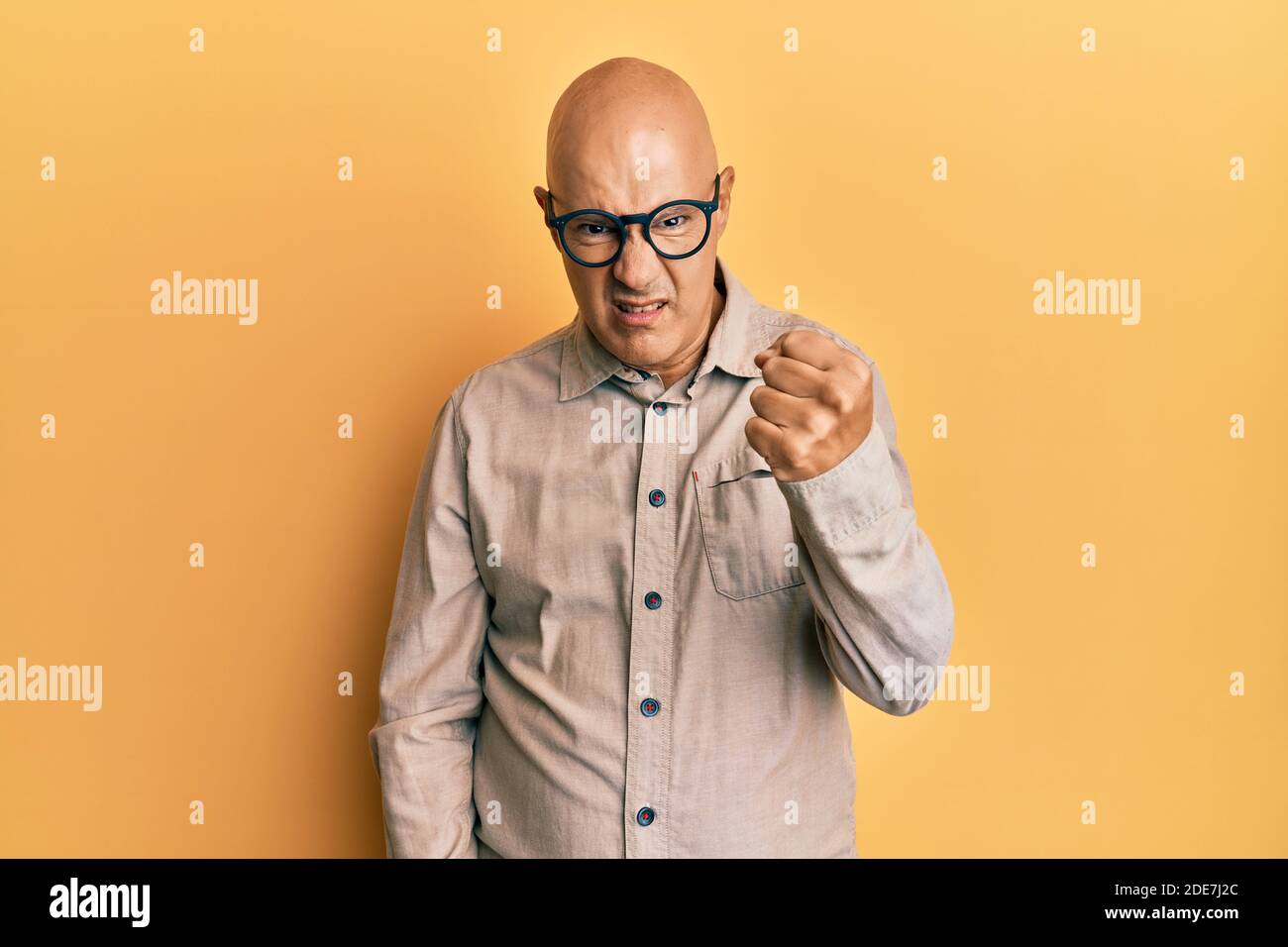 Middle age bald man wearing casual clothes and glasses angry and mad ...