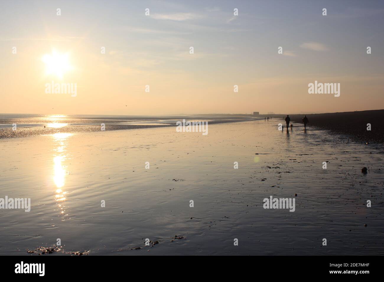 Pett Level Beach at Sunset. With pool of sea ocean water and rocks in ...