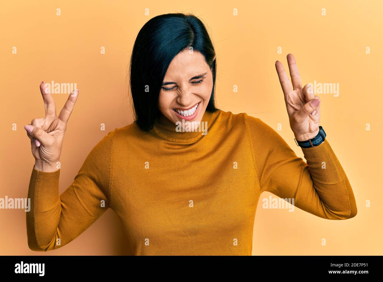 Young caucasian woman doing victory sign positive gesture smiling and ...
