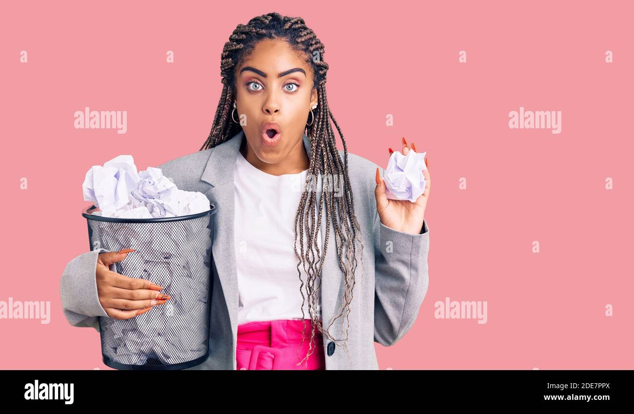 Young african american woman with braids holding paper bin full of ...