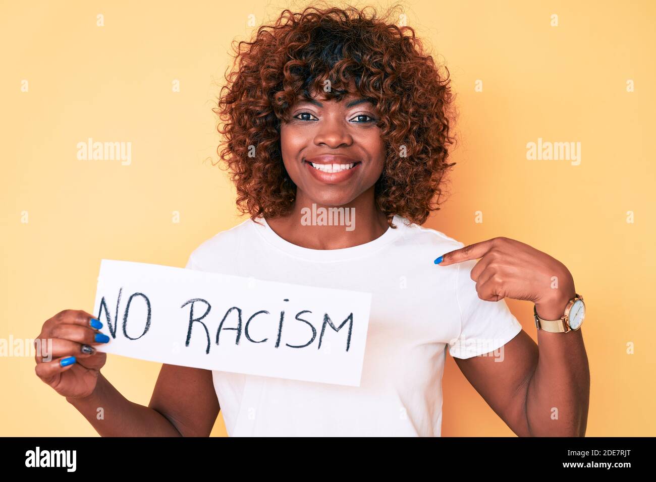 Young african american woman holding no racism banner pointing finger ...