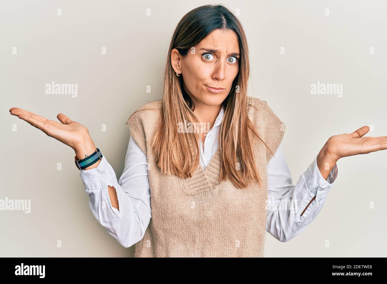 Brunette young woman wearing casual clothes clueless and confused with ...