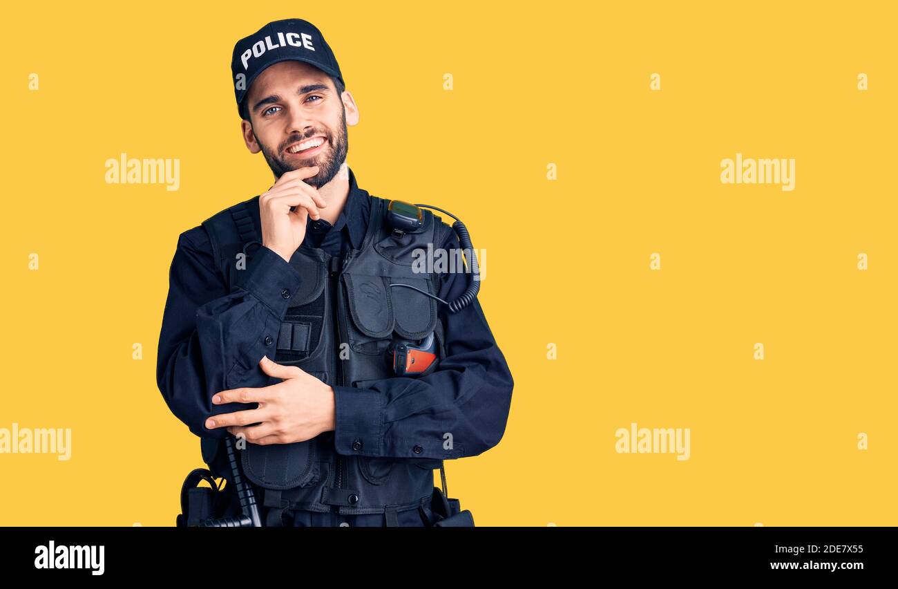 Young handsome man with beard wearing police uniform looking confident ...
