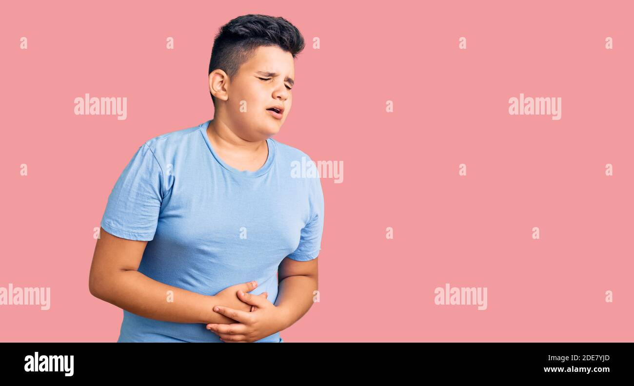 Little boy kid wearing sports workout clothes with hand on stomach ...