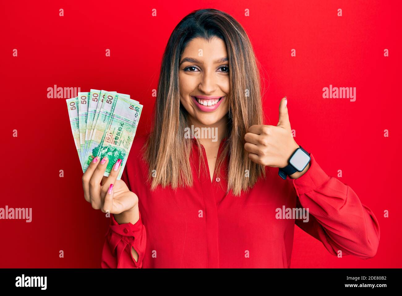 Beautiful brunette woman holding hong kong 50 dollars banknotes smiling ...