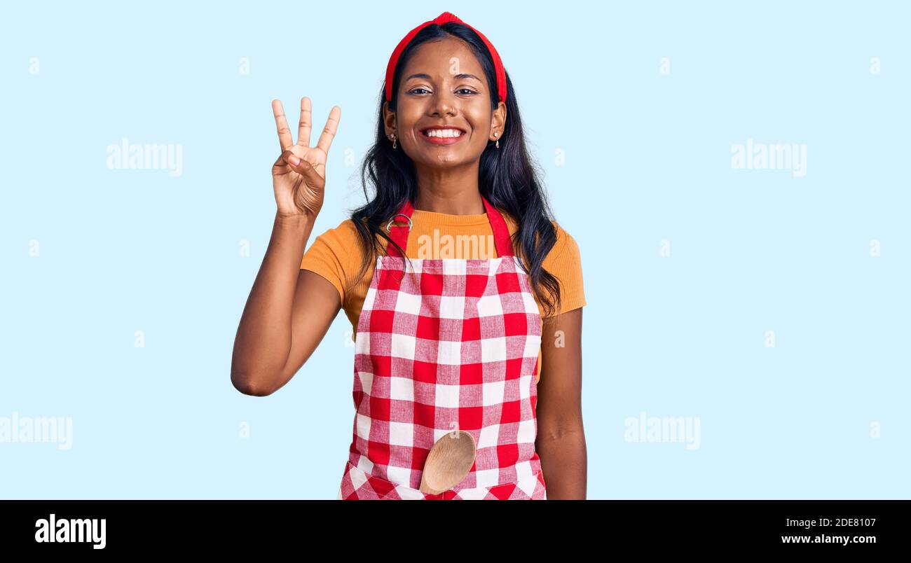 Young indian girl wearing professional baker apron showing and pointing ...