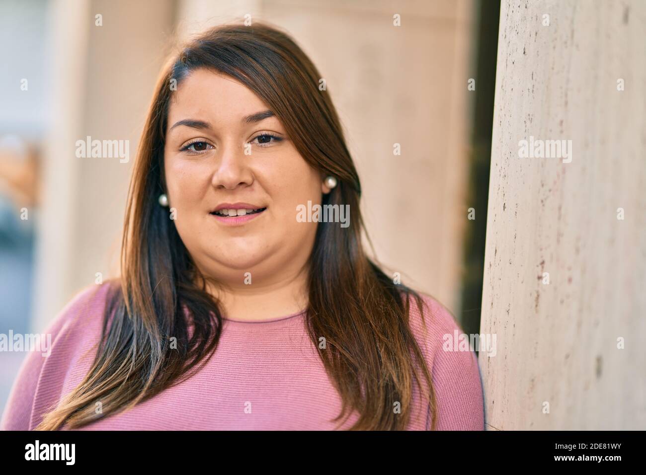 Young hispanic plus size woman smiling happy standing at the city Stock ...