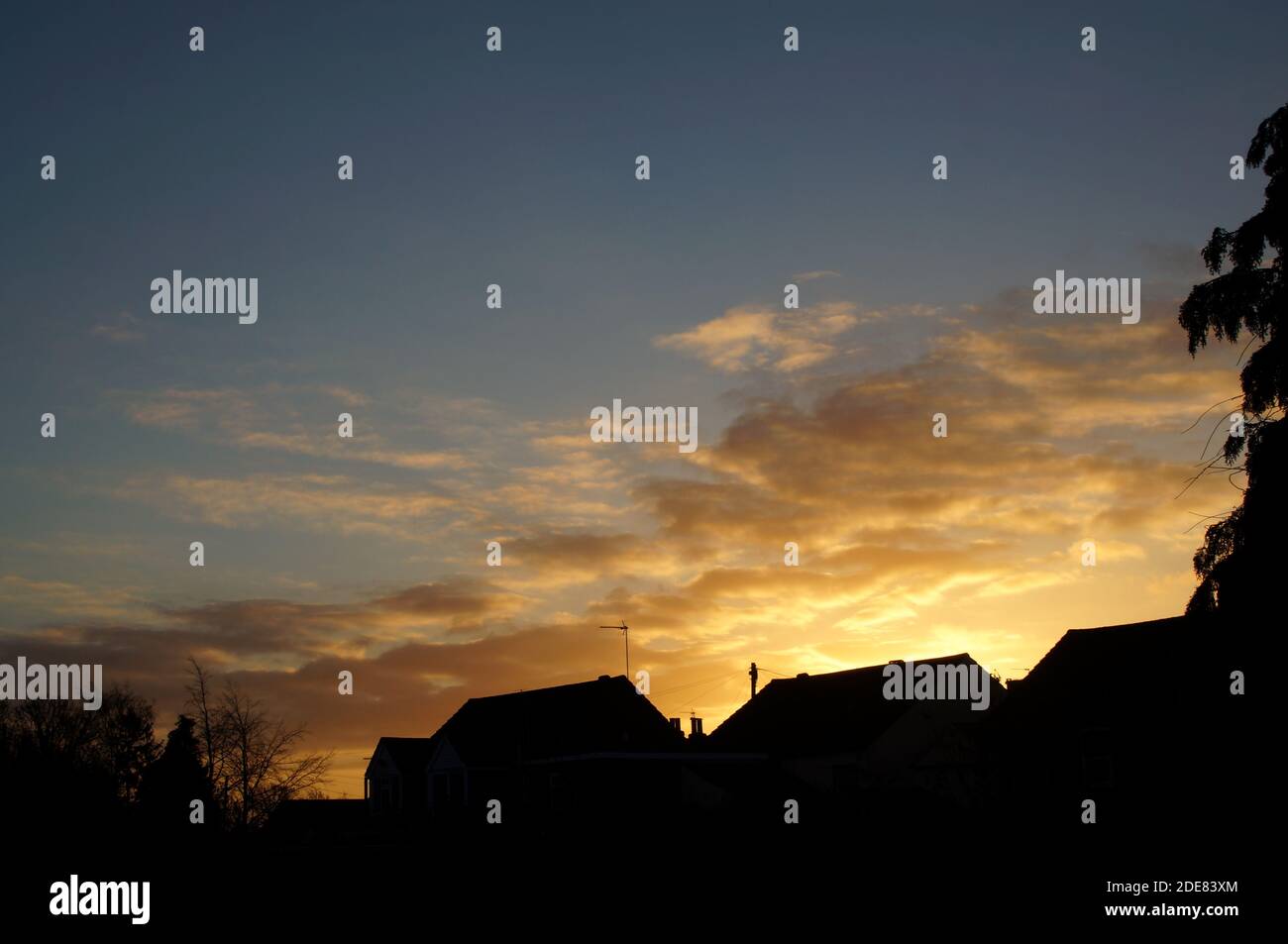 Blue sky sunrise over dark house rooftops Stock Photo - Alamy
