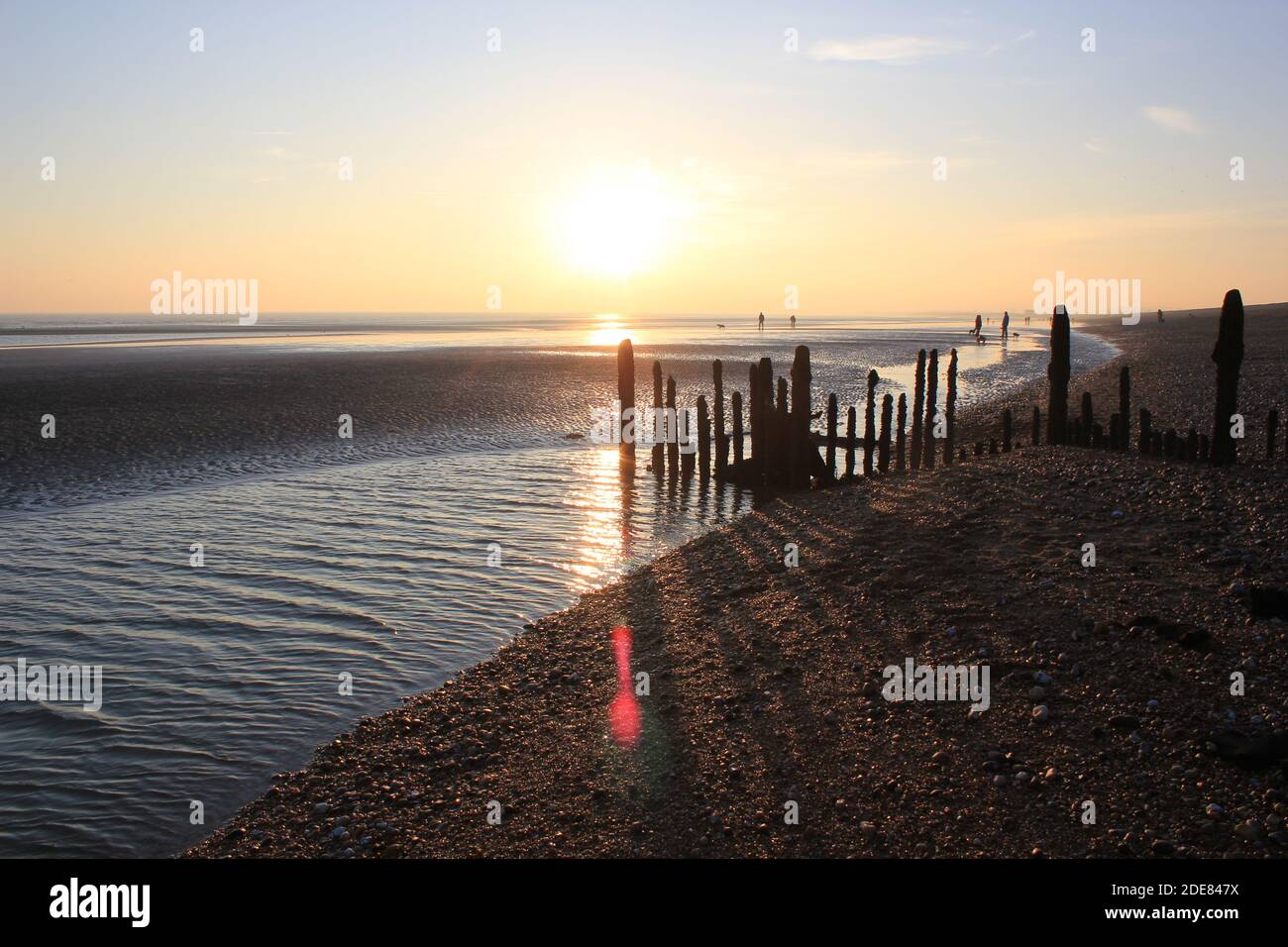 Pett Level Beach at Sunset. With pool of sea ocean water and rocks in ...