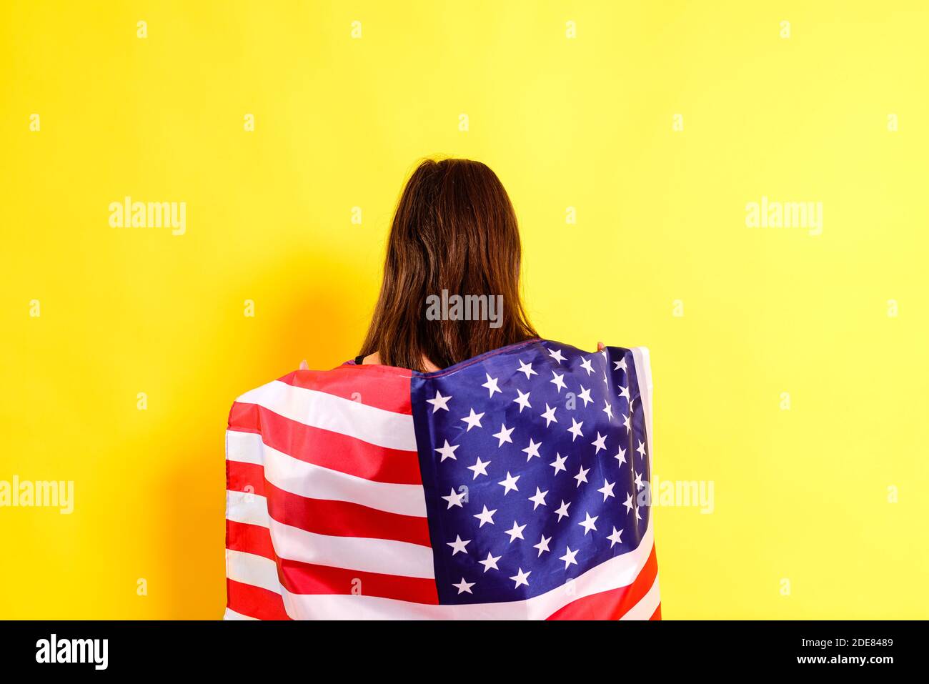 Young embarrassed woman covers herself with an American flag to ...