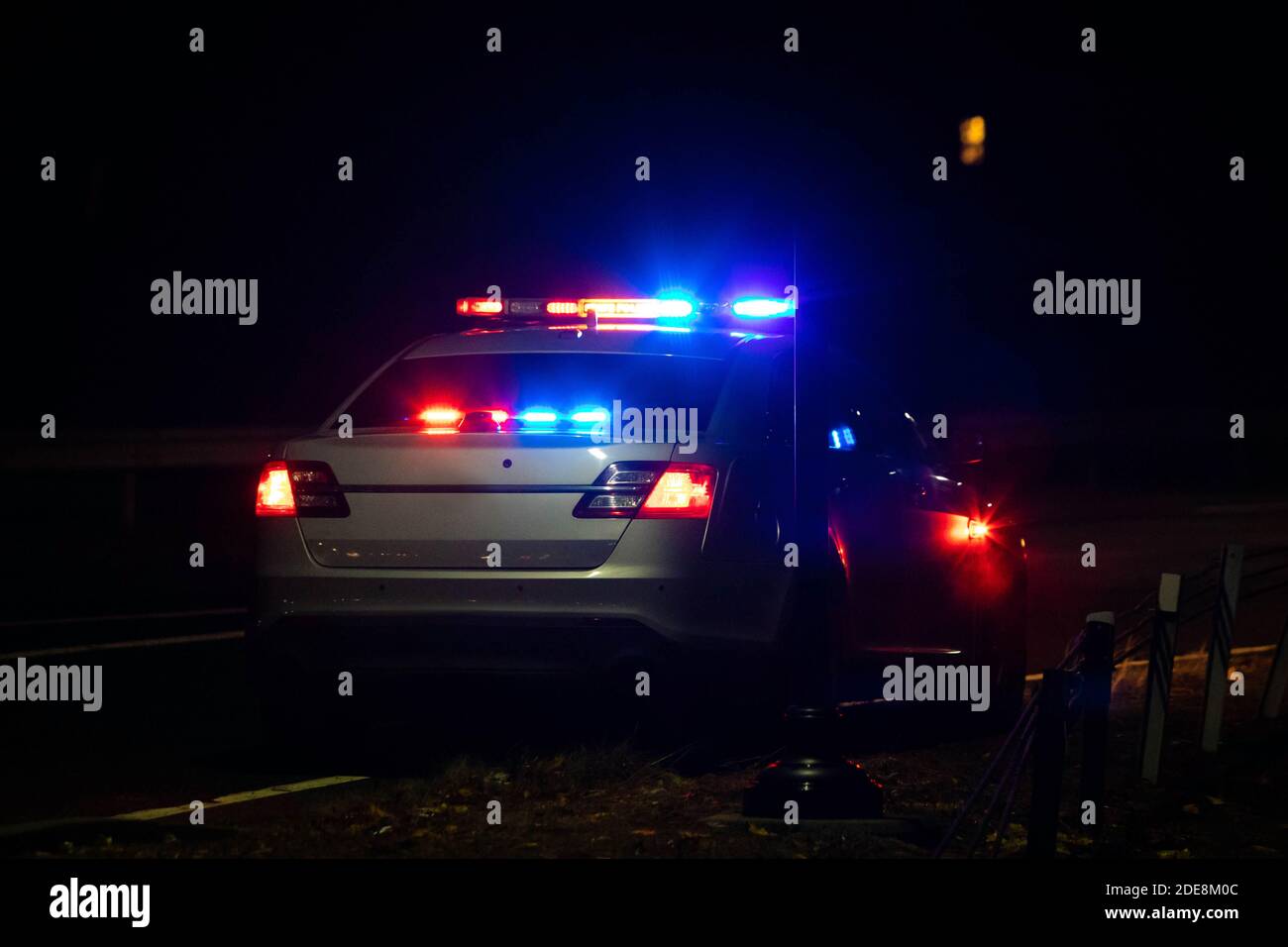 Police emergency flash lights at night from the back on highway road ...