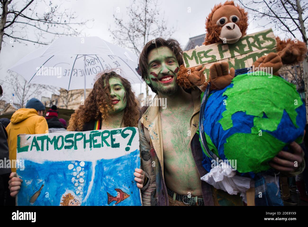 A couple, with green paint over their bodies, carry signs during a ...