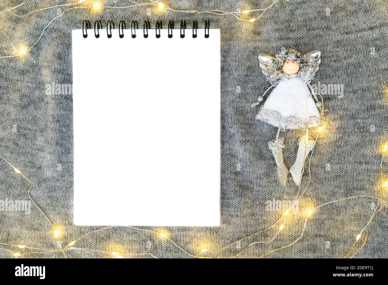 White notepad and christmas angel with lights from a garland Stock ...