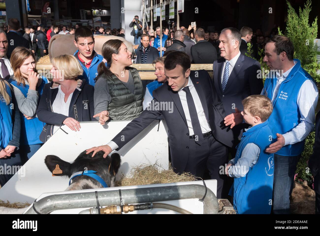 French President Emmanuel Macron touchs a cow during his visit at the ...