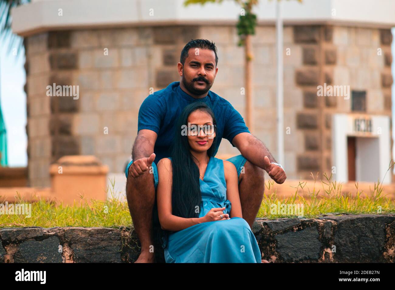 Lovely Sri Lankan smiling couple gives thumbs up while sitting in front ...