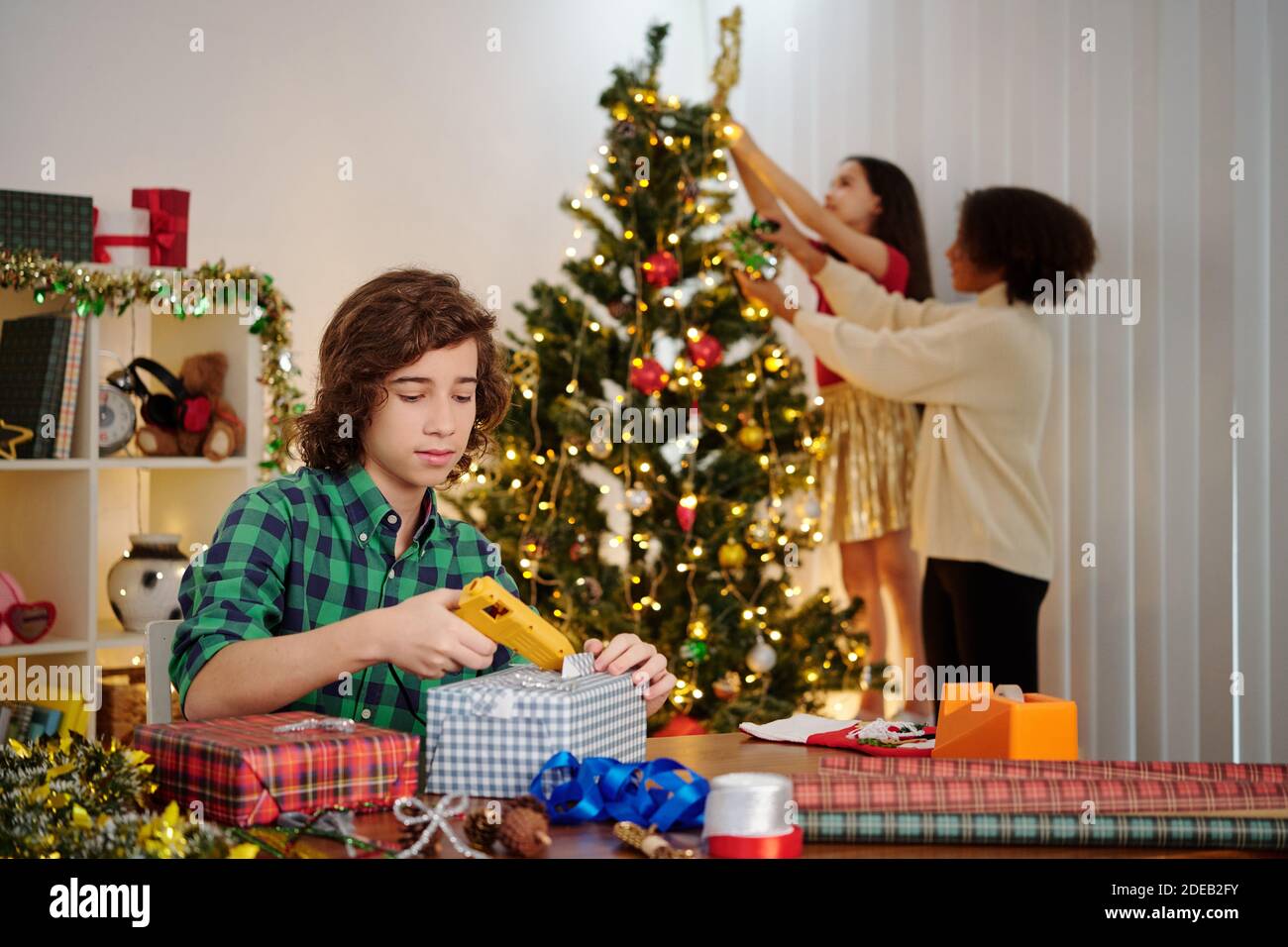 Boy wrapping present for friends Stock Photo - Alamy