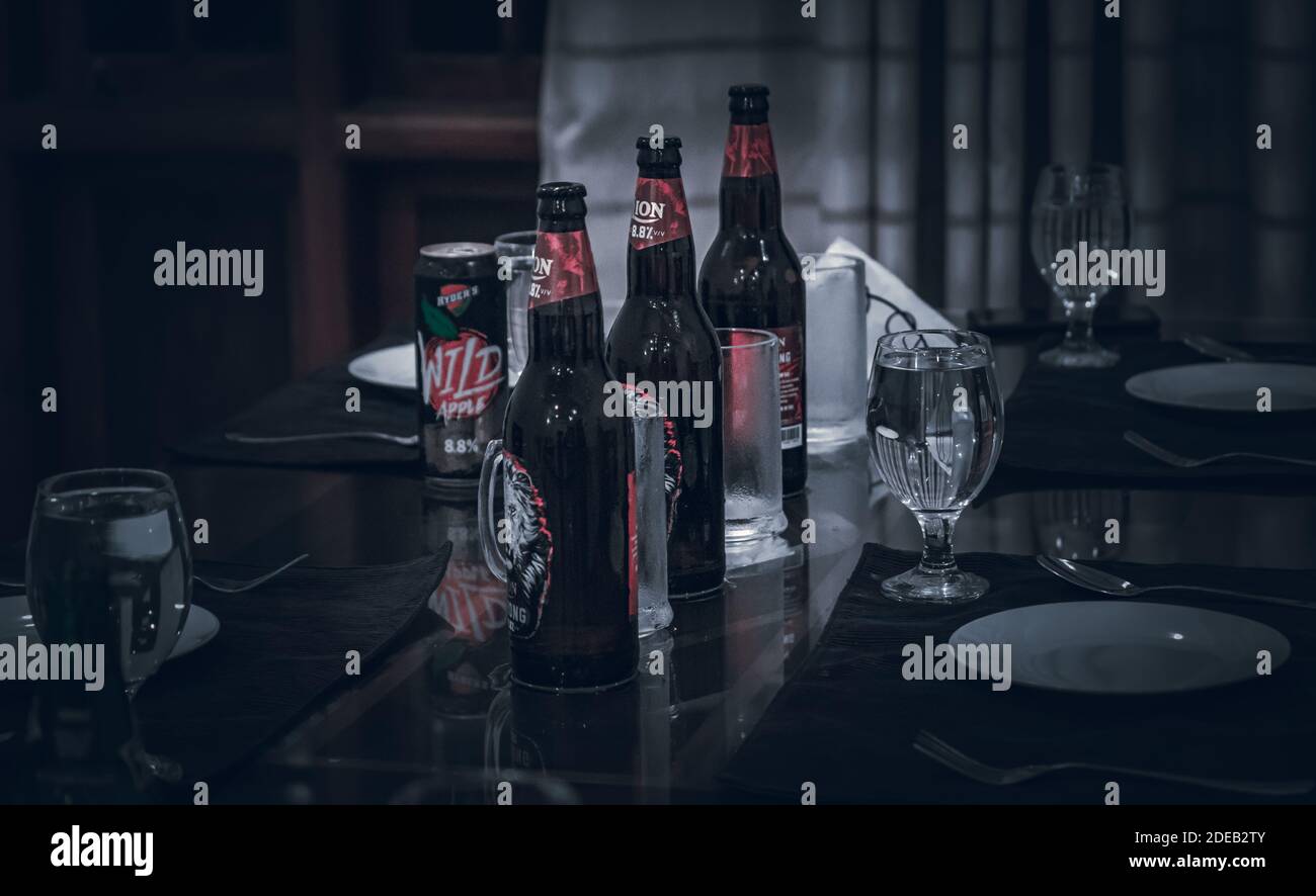 small gathering with beers and plates on the table night lights dark ...