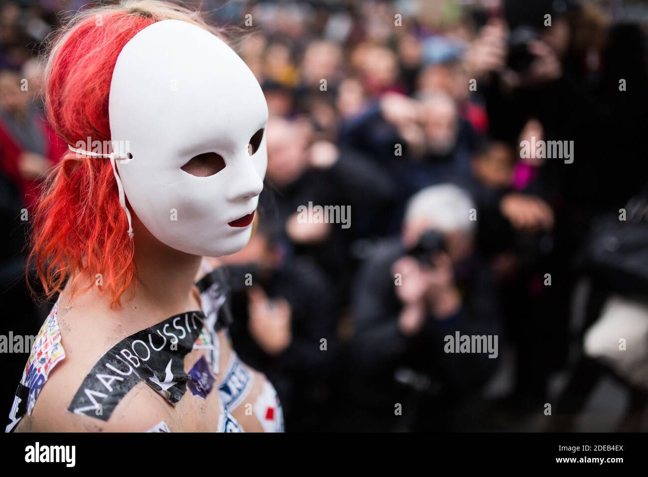 A activist wearing logos of international brands poses during a women's ...