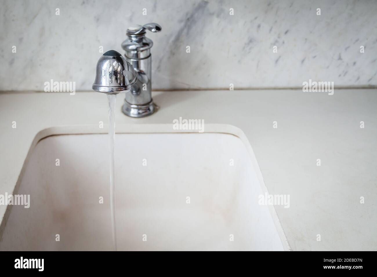 Water drop from faucet white modern white sink Stock Photo - Alamy