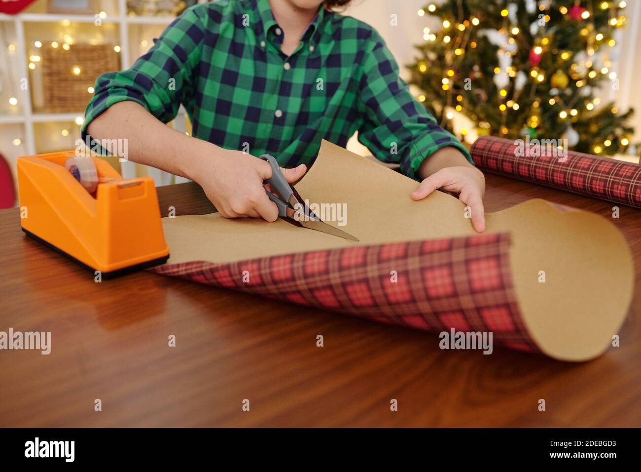 Teenage boy cutting wrapping paper Stock Photo - Alamy