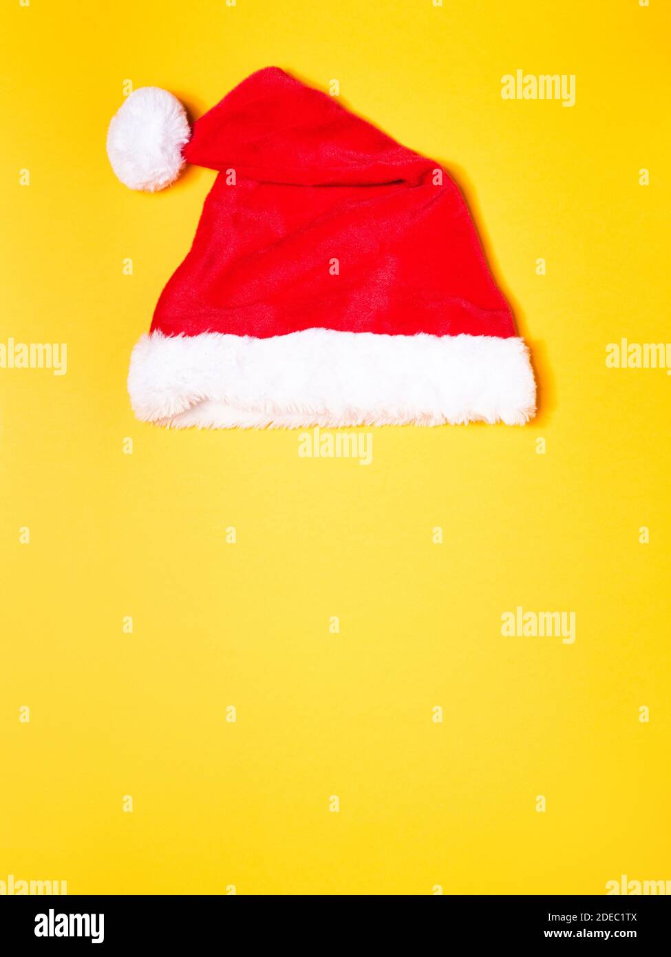 Red Santa Claus hat on paper yellow background. Christmas concept. Flat ...