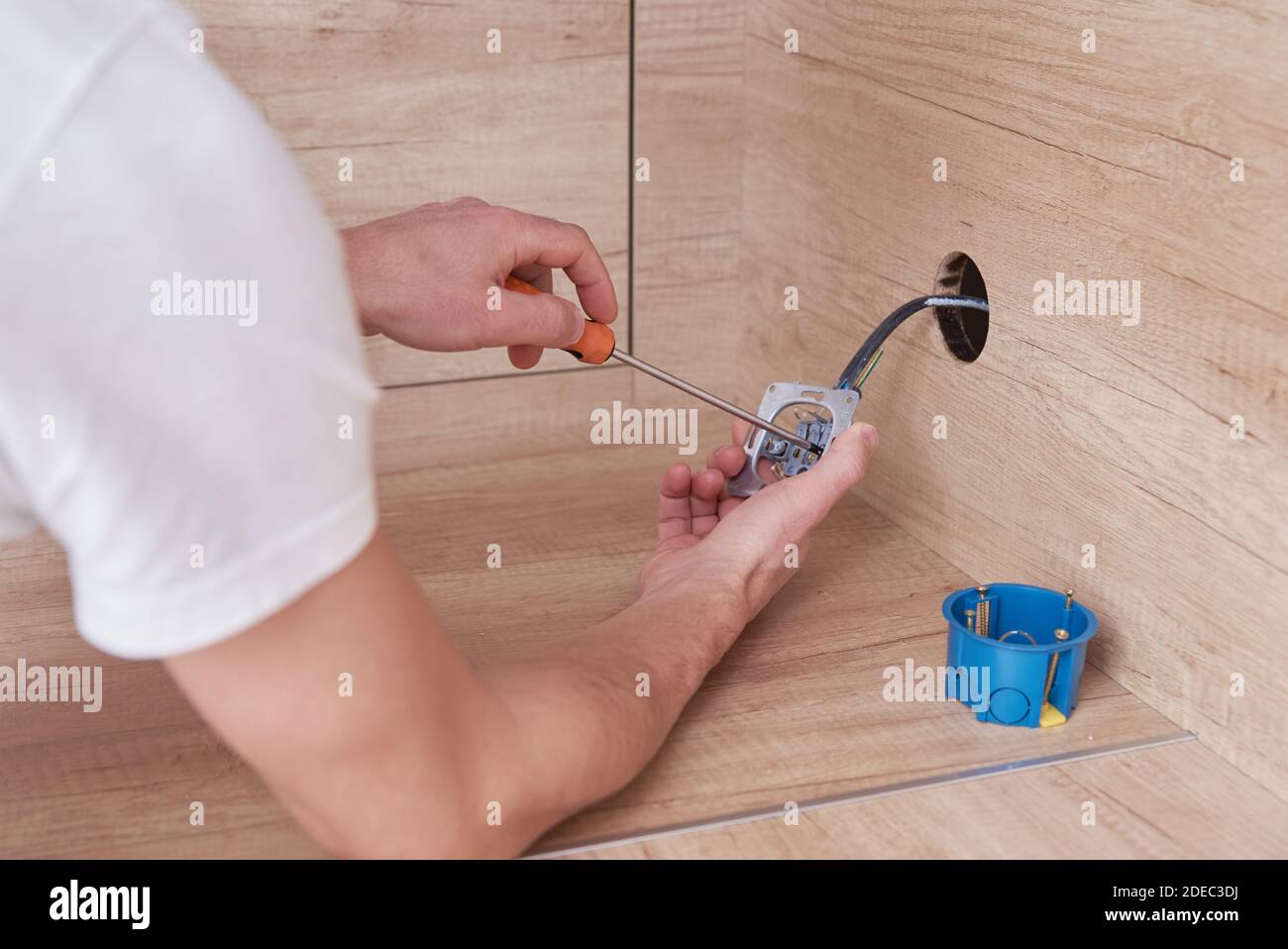 Electrician installing a socket plug in the kitchen. Renovation concept ...