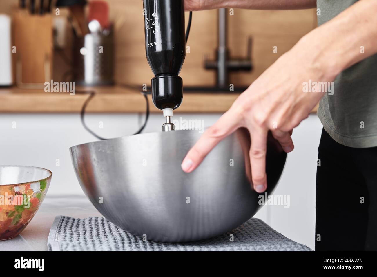 Woman in the kitchen cooking a cake. Hands beat the dough with an ...