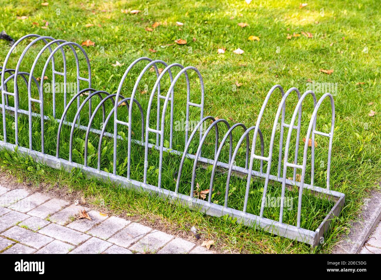 A high angle shot of bicycle parking racks in a park under the sunlight ...