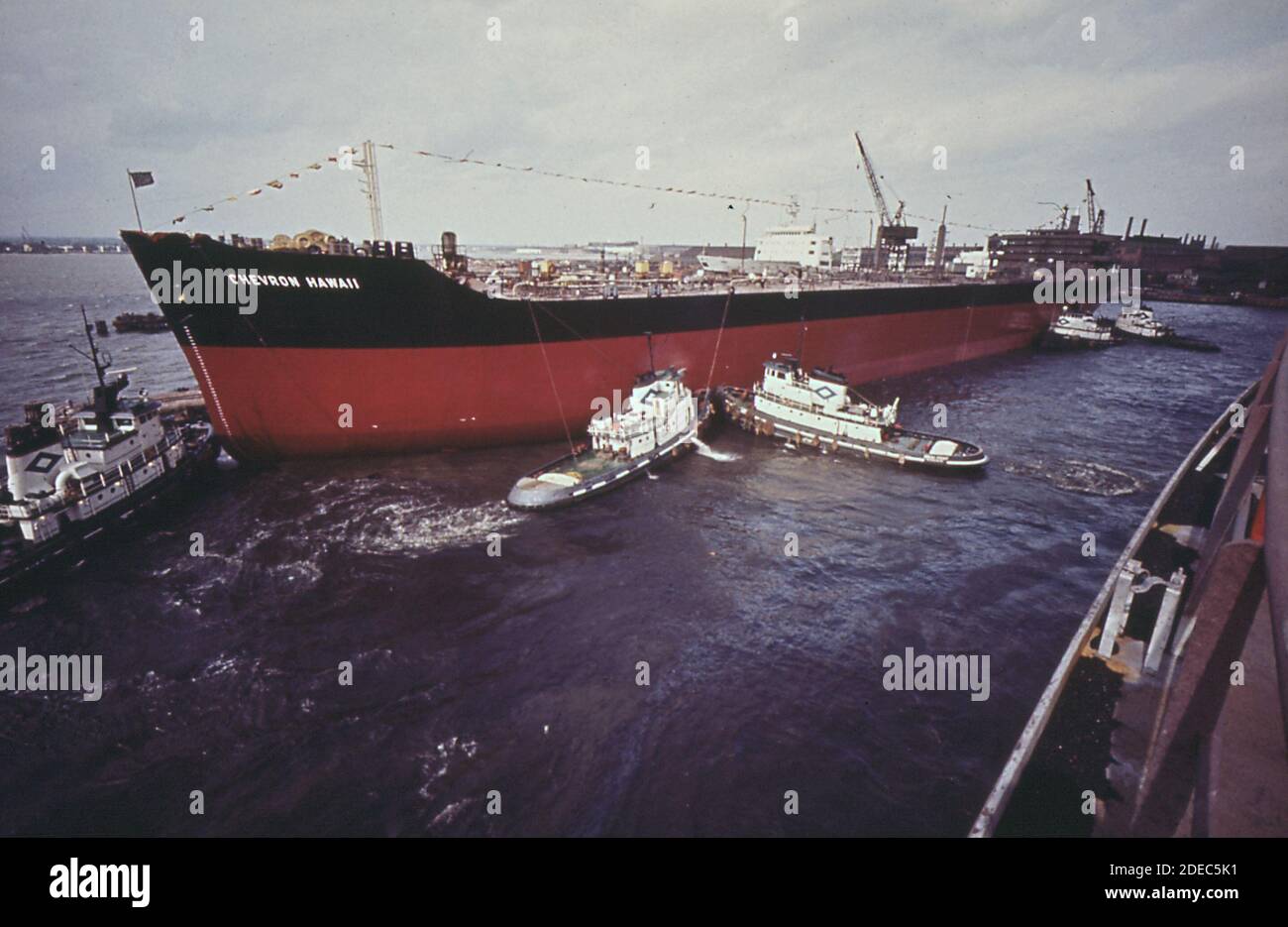 "Tugboats move the newly launched tanker; ""Chevron Hawaii;"" to its ...