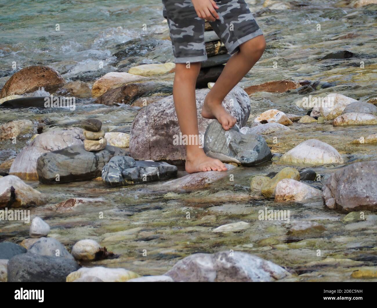 Boy standing on stones hi-res stock photography and images - Alamy