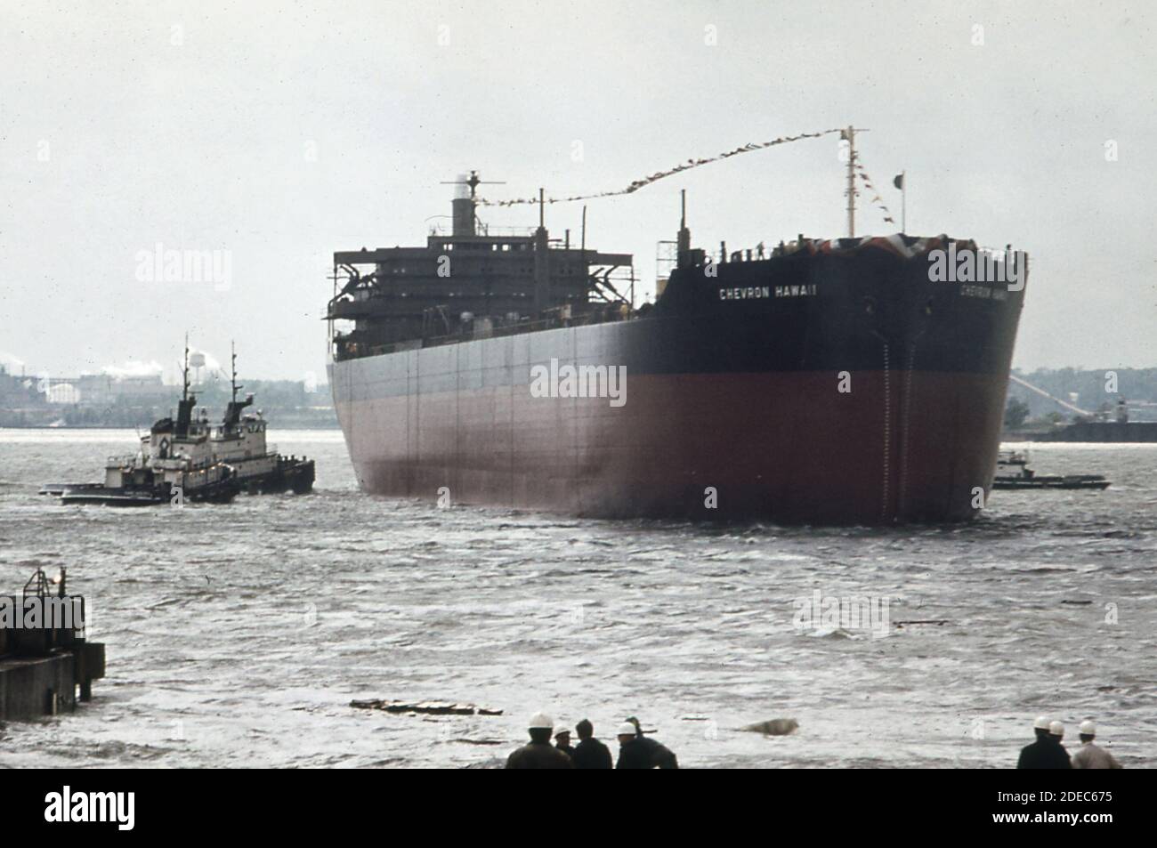 "Tugboats move the newly launched tanker; ""Chevron Hawaii;"" to its ...