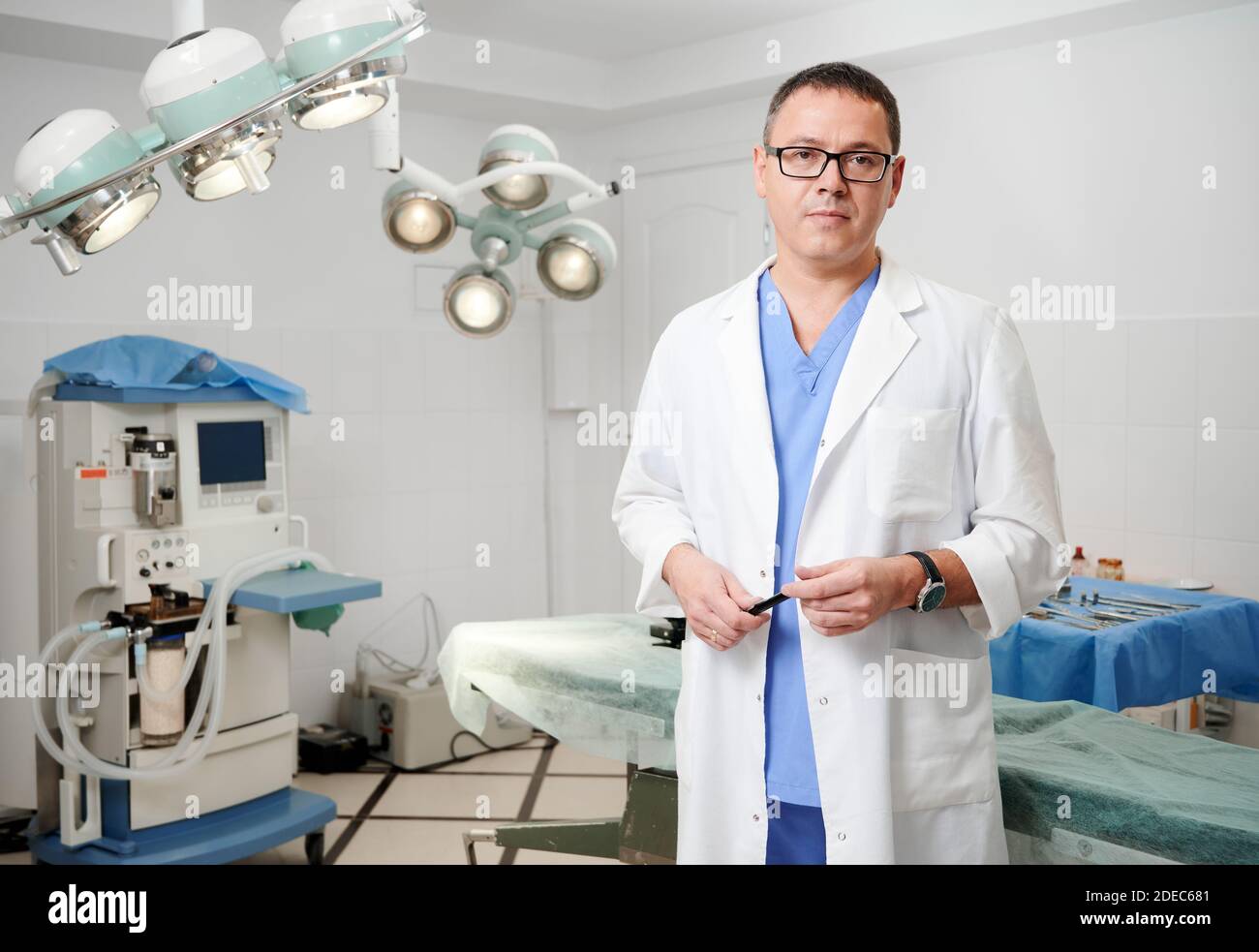 Front view of man surgeon in glasses looking at camera with serious ...