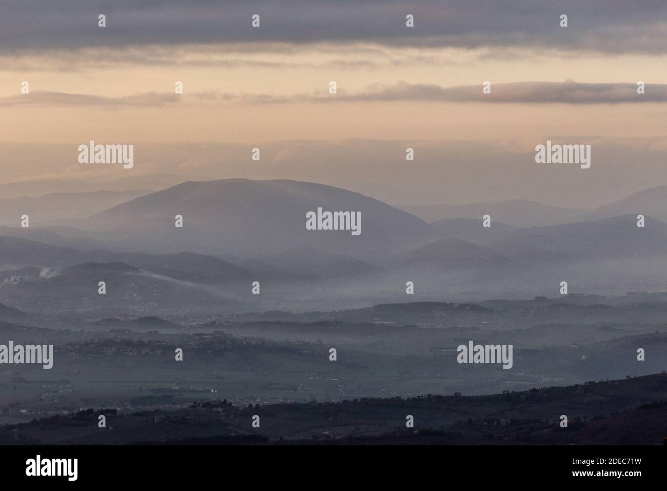 Mist and fog between valley and layers of mountains and hills at dusk ...