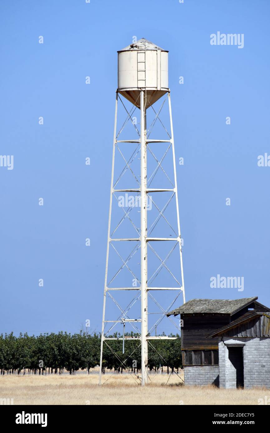 A vertical shot of a water tower structure under a perfectly clear blue ...
