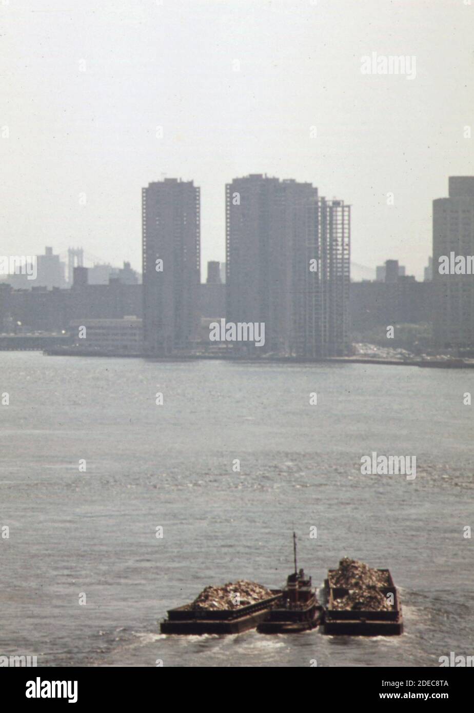 1970s Photo - (1973) - Tugboat tows garbage scows down the East River ...