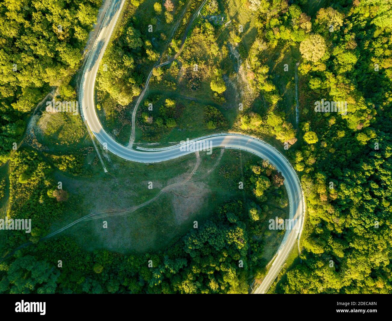 Aerial view over mountain road going through forest landscape Stock ...