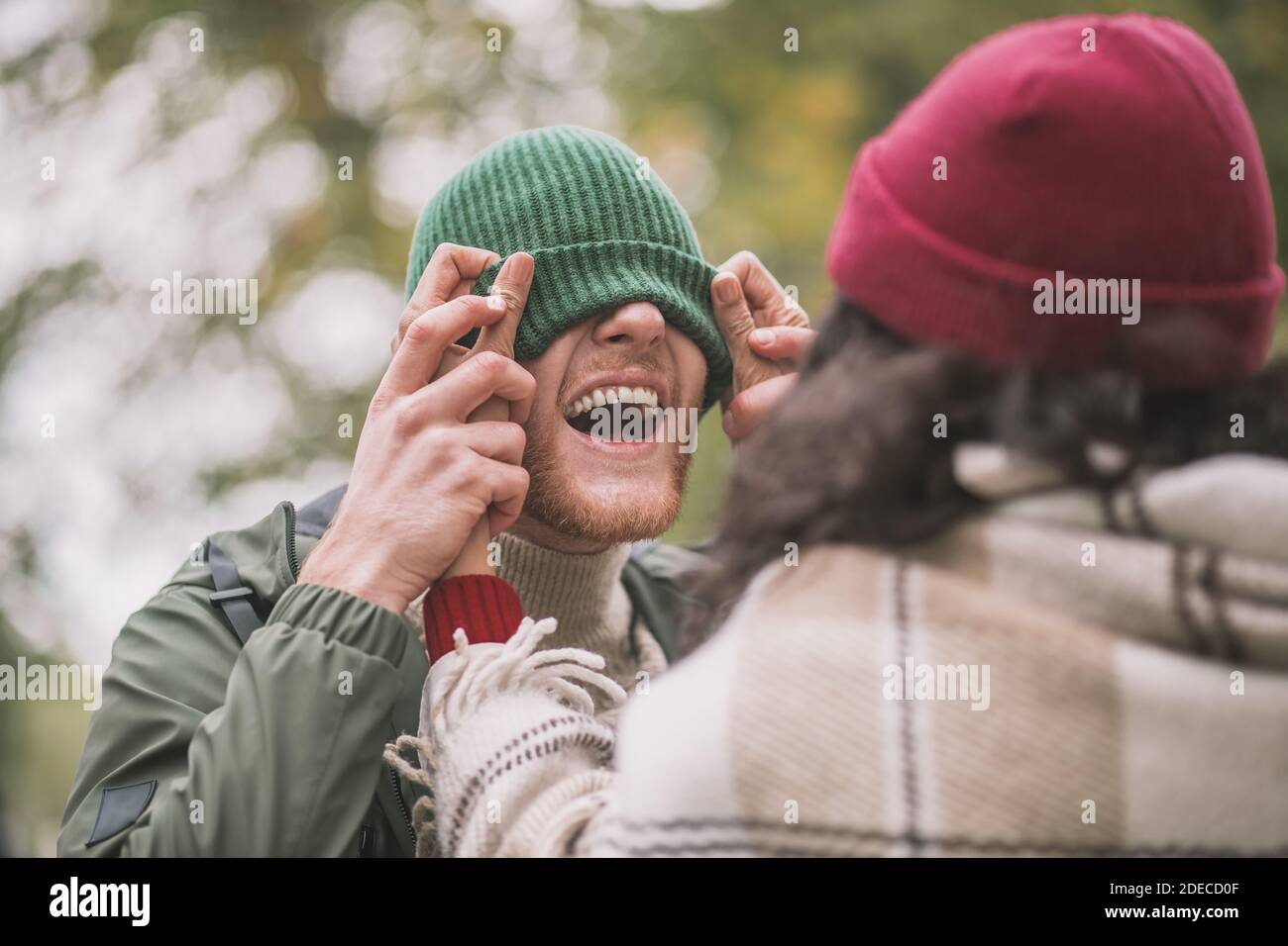 Woman fixing a hat on her partners head Stock Photo - Alamy