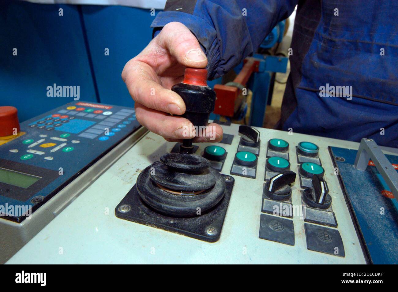 man holding a joystick of a machine, automation in a carpenters ...